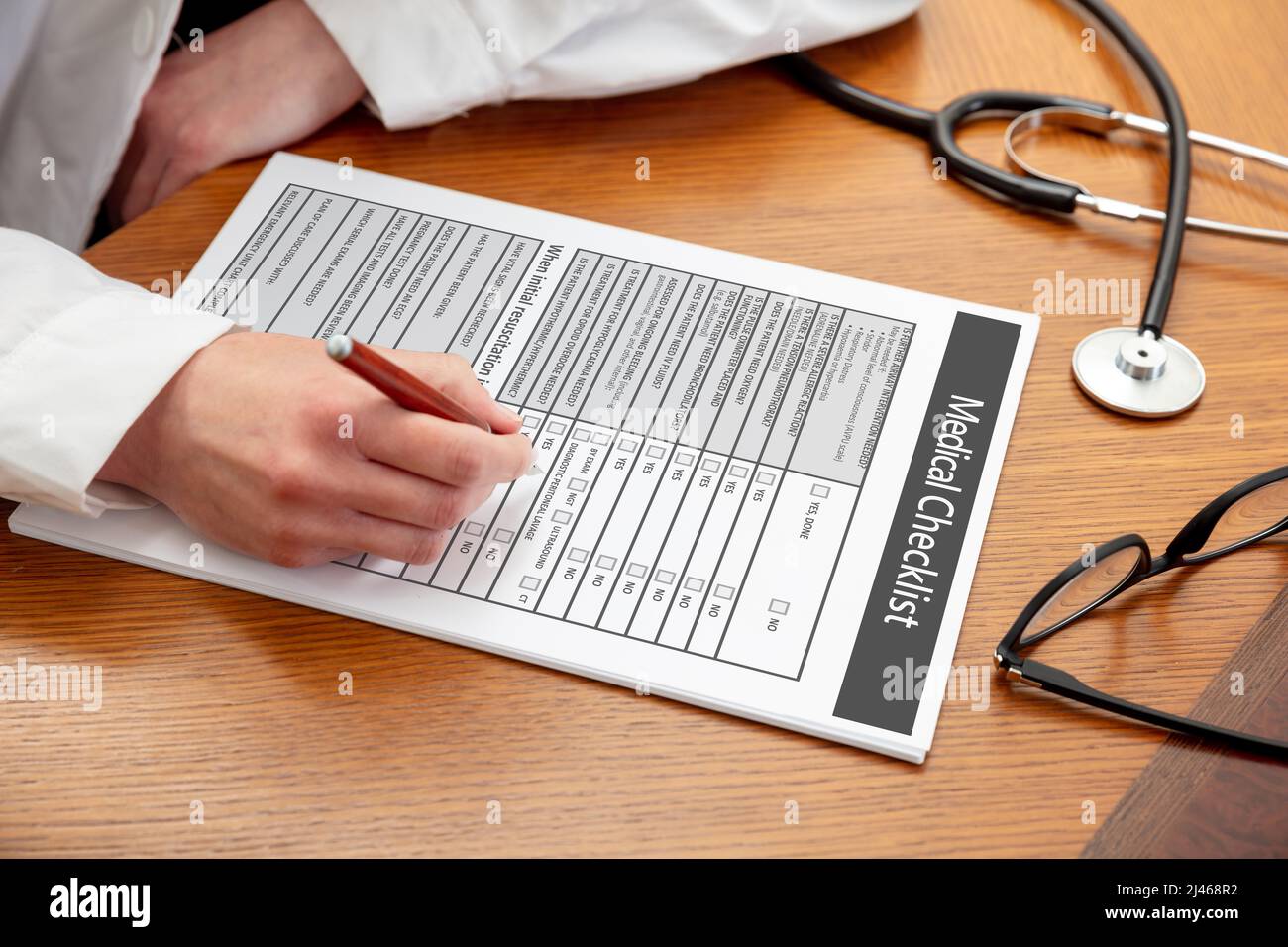 Medical checklist. Woman doctor holding a pen, close up view, wooden ...