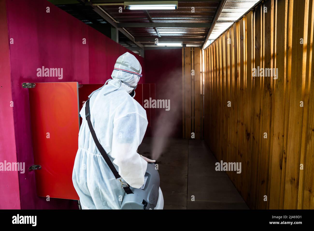 Professional technical man in prevention suit with his sterilizing machine and disinfecting ...
