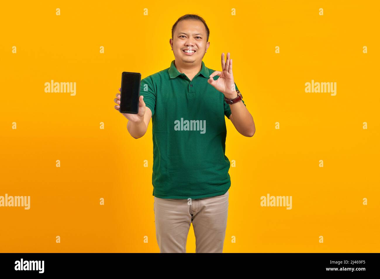 Happy Asian man showing mobile phone blank screen and hand gesture okay ...