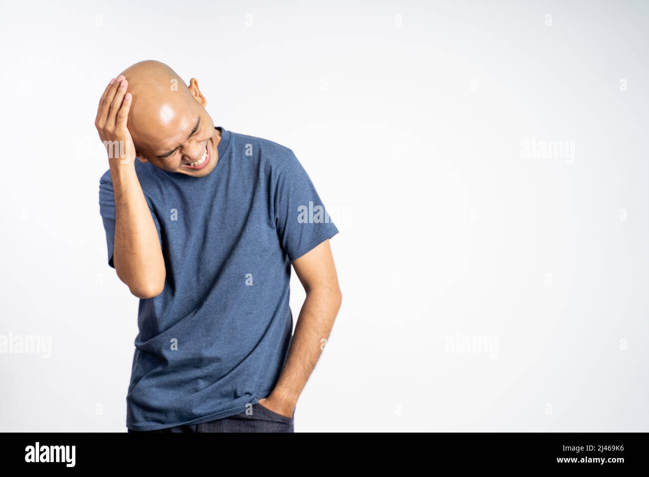bald man laughing holding his bald head Stock Photo - Alamy