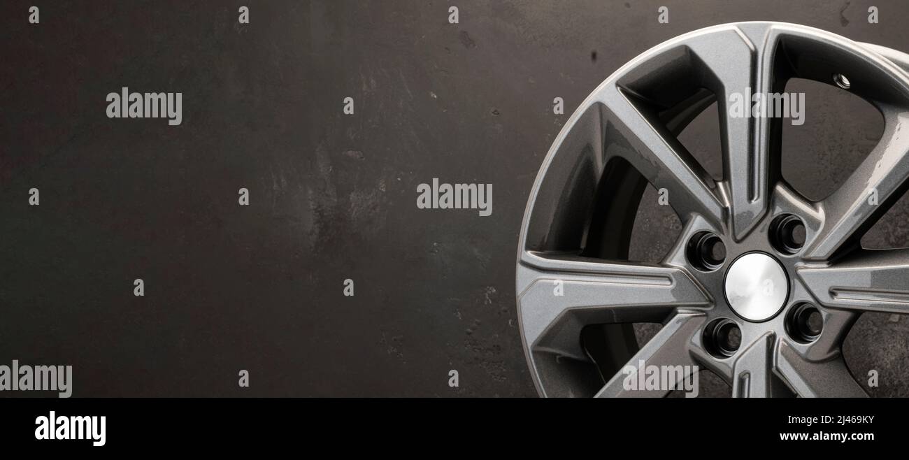 new grey alloy wheels on a dark textured black background. car wheel ...