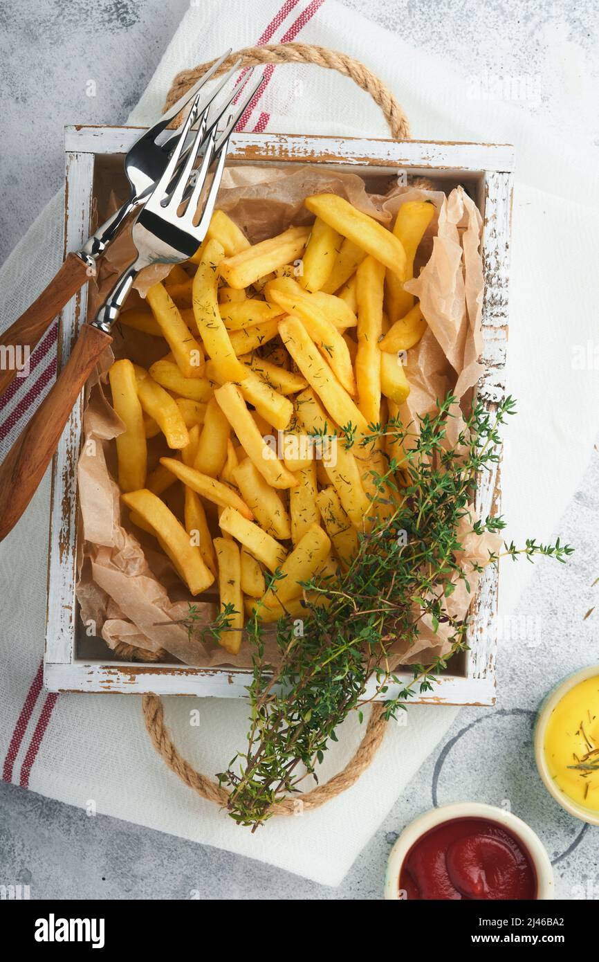 French fries. Tasty French fries server on parchment paper on wooden ...