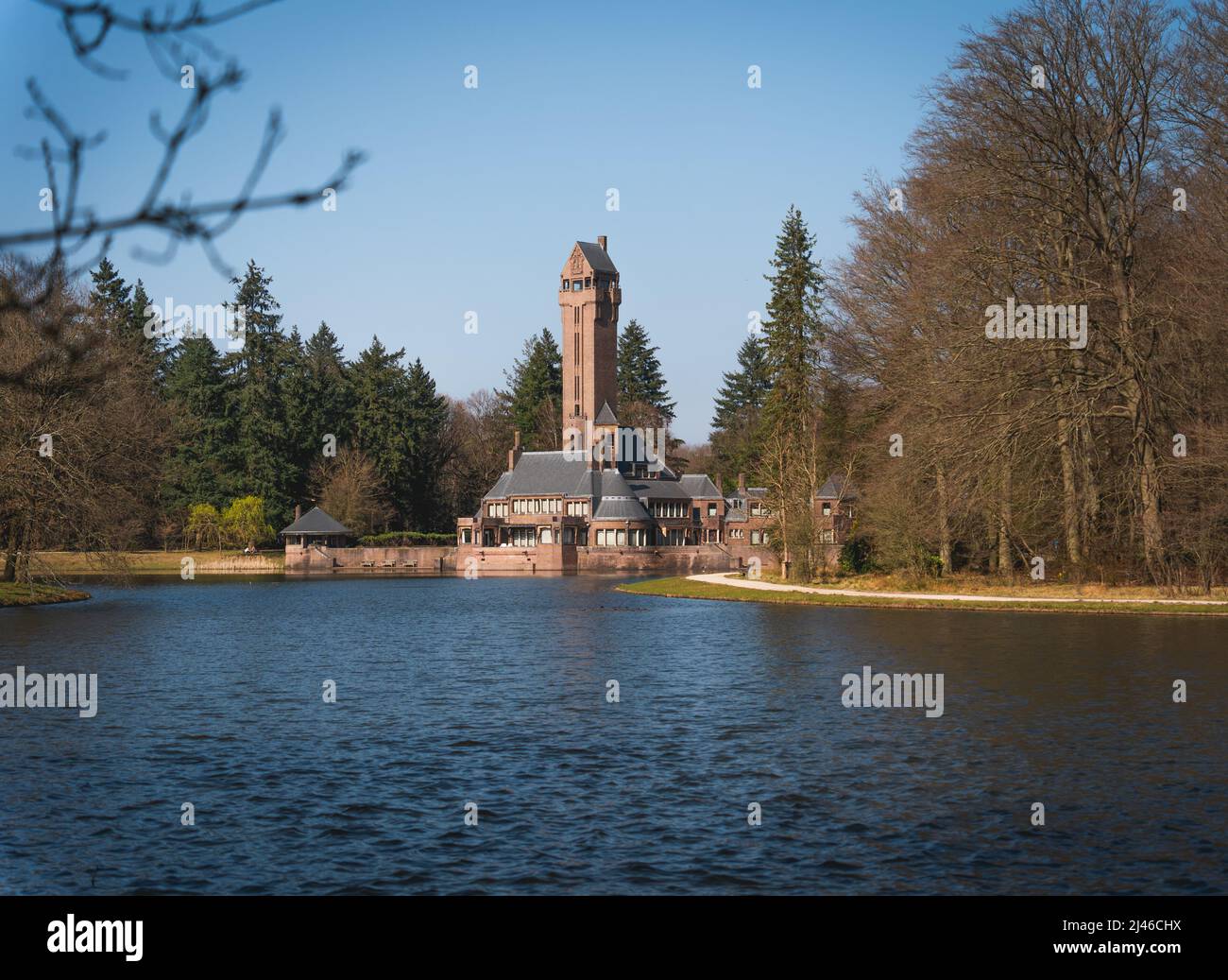 Building inside of a forest with a lake in front of it Stock Photo - Alamy