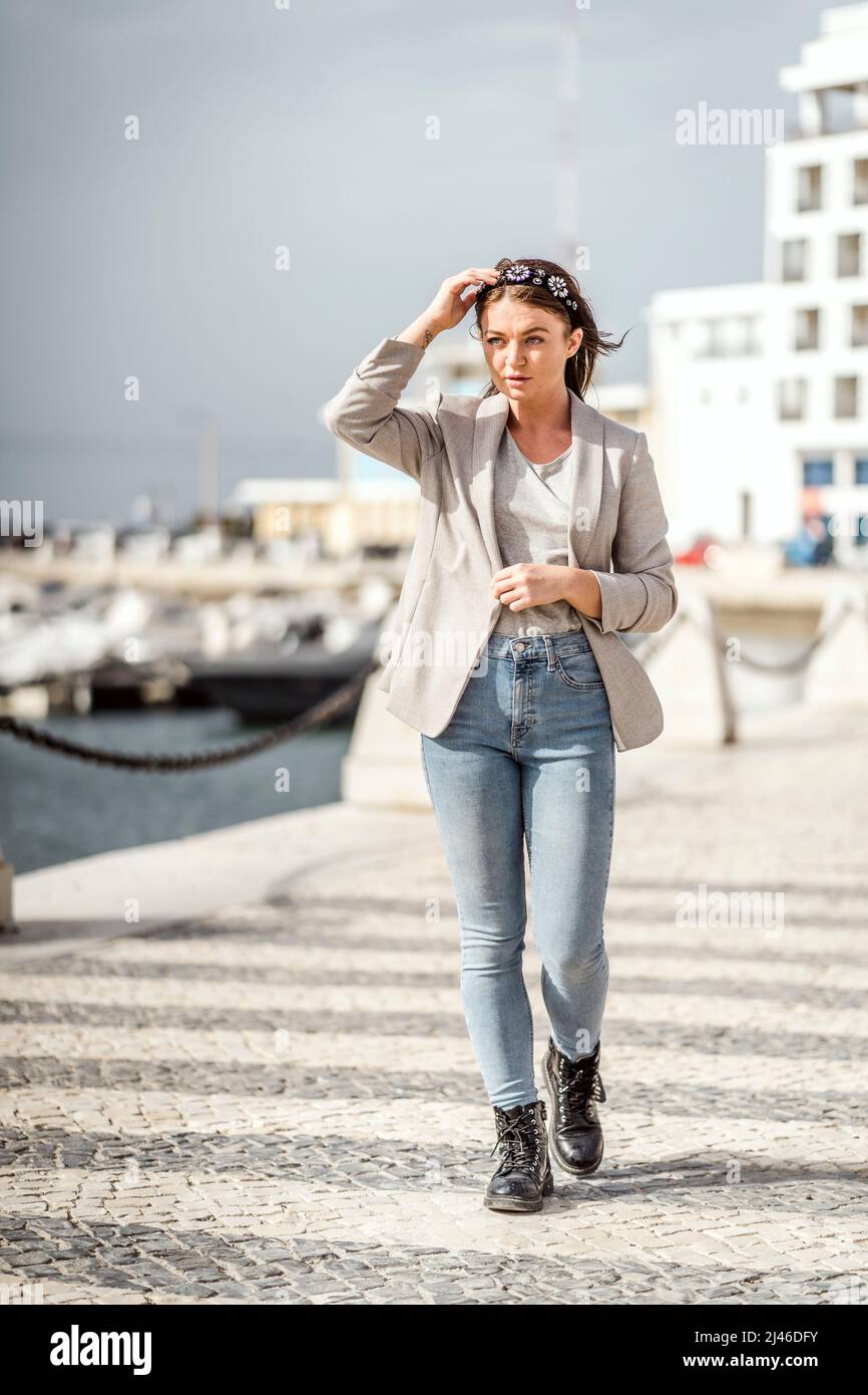 A portrait of a young confident woman walking in the city by marina ...