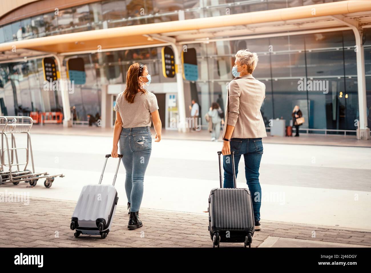Female friends with luggage approaching the airport ready for the trip ...