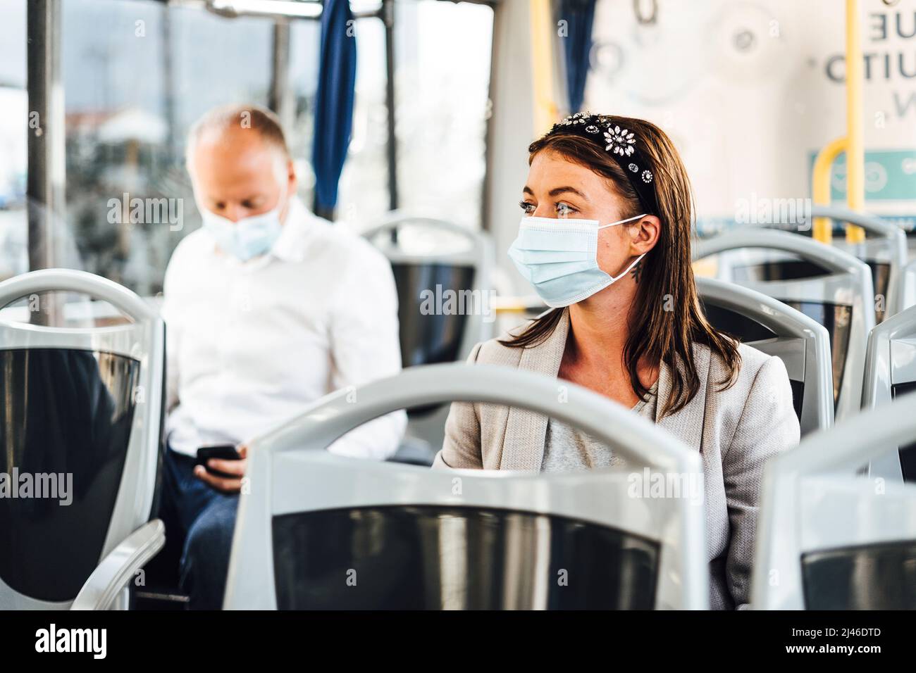 Travelers wearing protective masks commuting by public bus Stock Photo ...