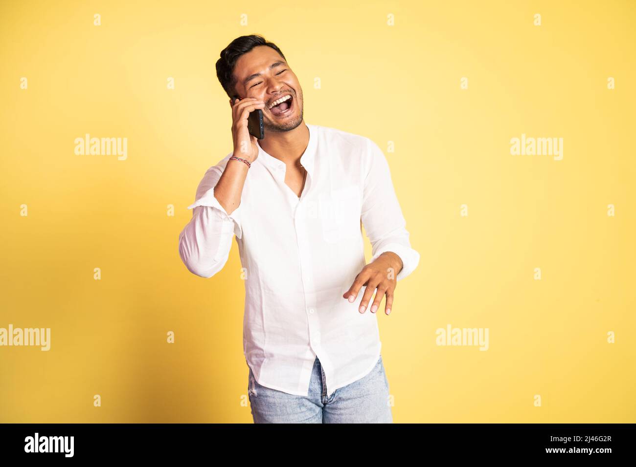 young asian man laughing while making phone call Stock Photo - Alamy