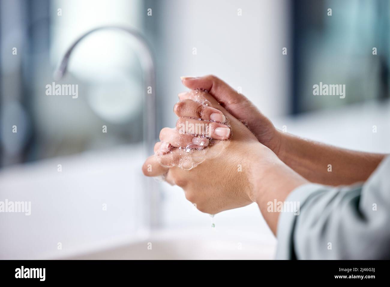 Keep yourself and others safe. Shot of a woman washing her hands in the ...