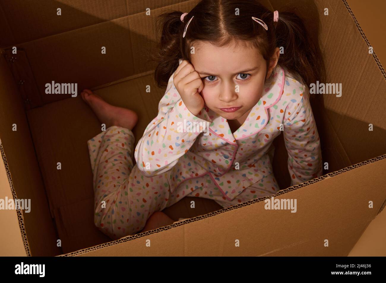 Studio shot of a beautiful upset little child girl looking at the ...