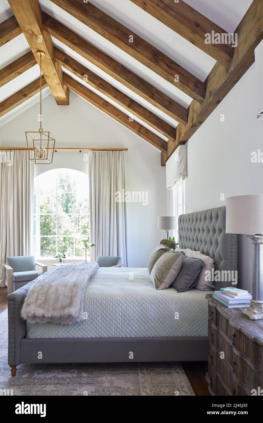 Bedroom towards arch window with wooden beams Stock Photo - Alamy