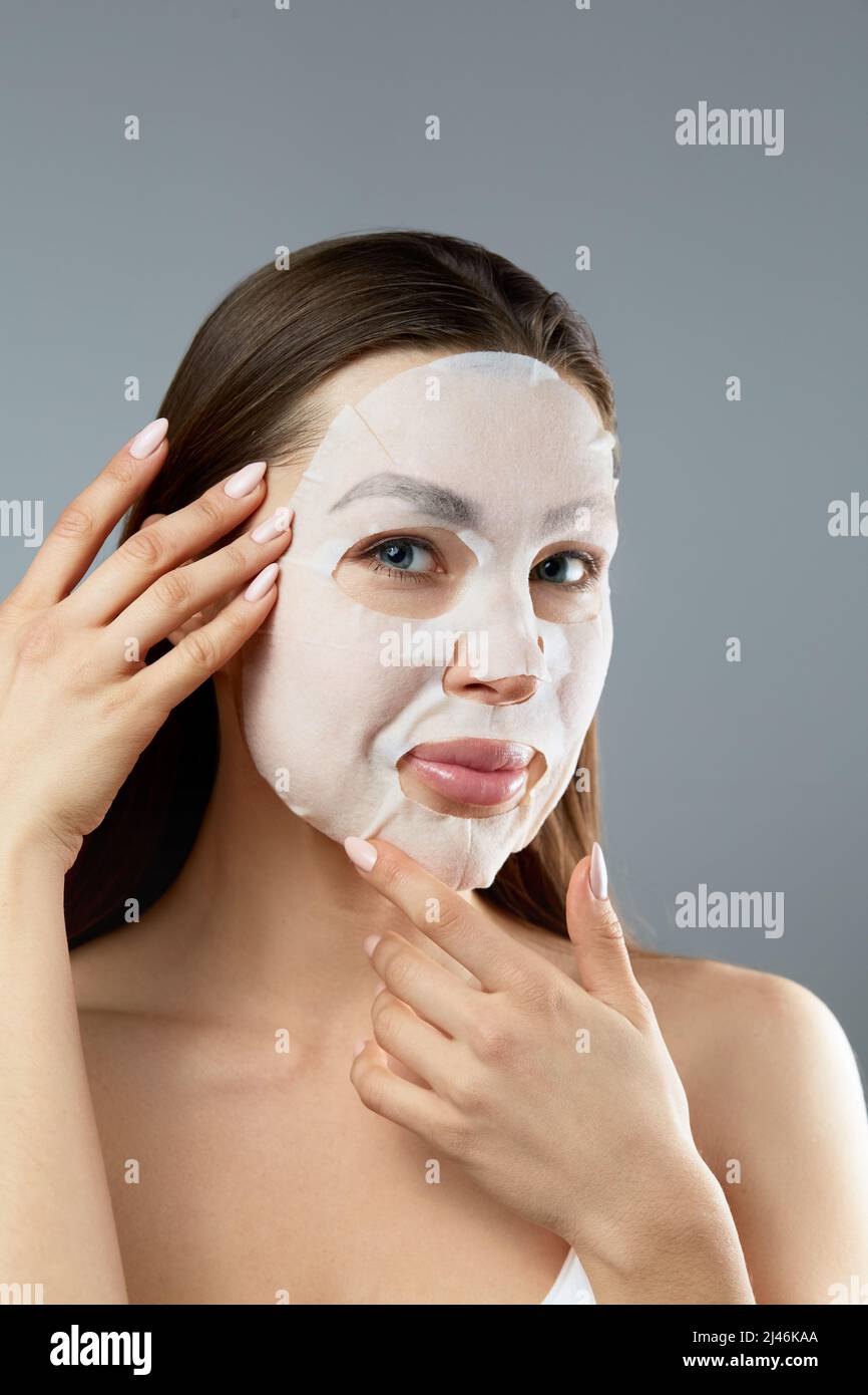 Face care and beauty treatments. Woman with a cloth moisturizing mask ...