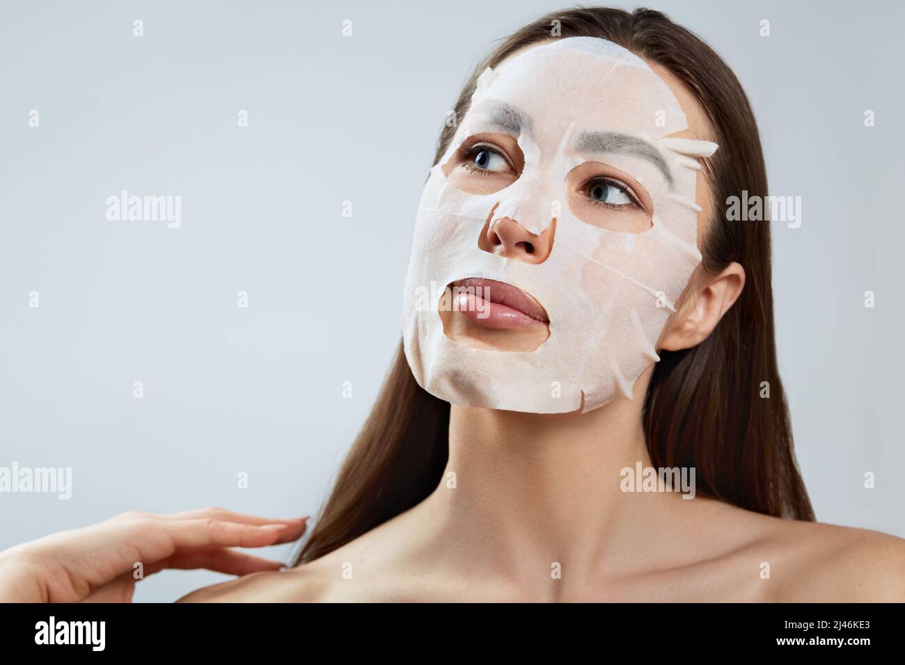 Face care and beauty treatments. Woman with a cloth moisturizing mask ...