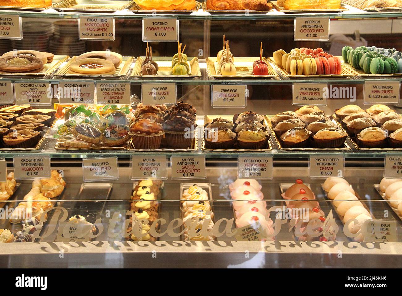Variety of pastries and cakes for sale at a business in Italy Stock ...