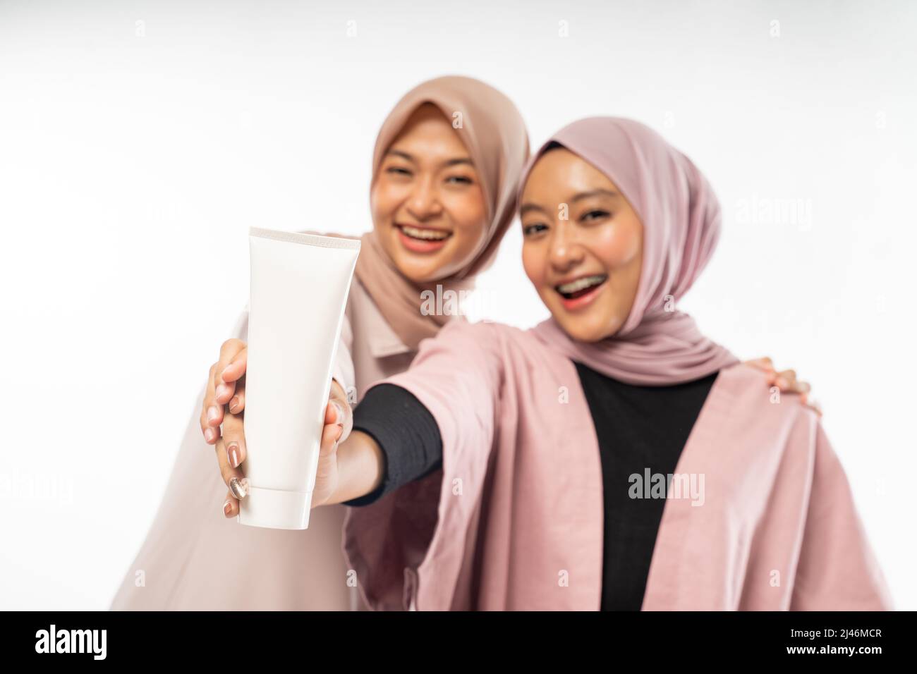 two muslim beauty friend holding a tube cosmetic product for skincare ...