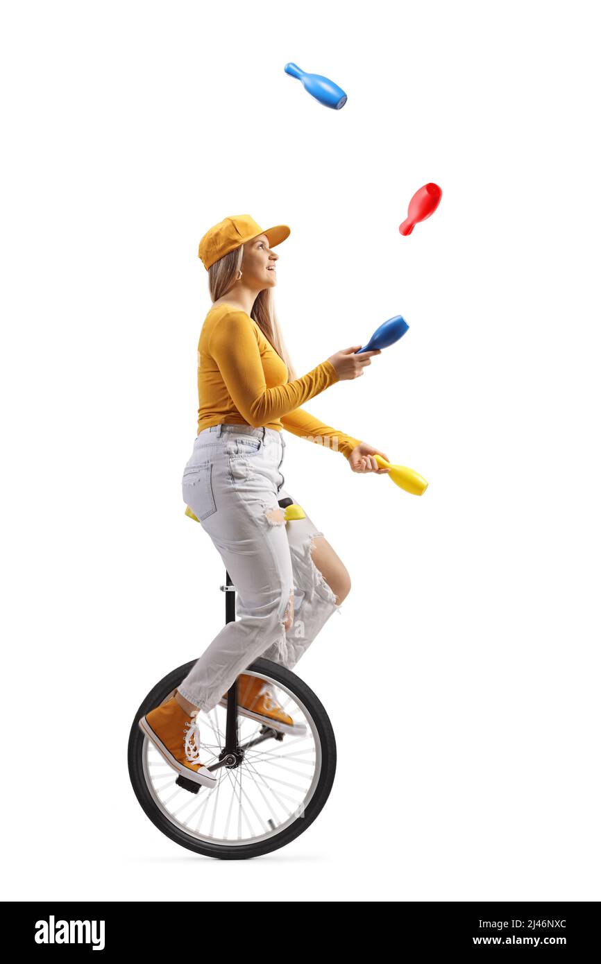 Young female riding a unicycle and juggling isolated on white background Stock Photo - Alamy