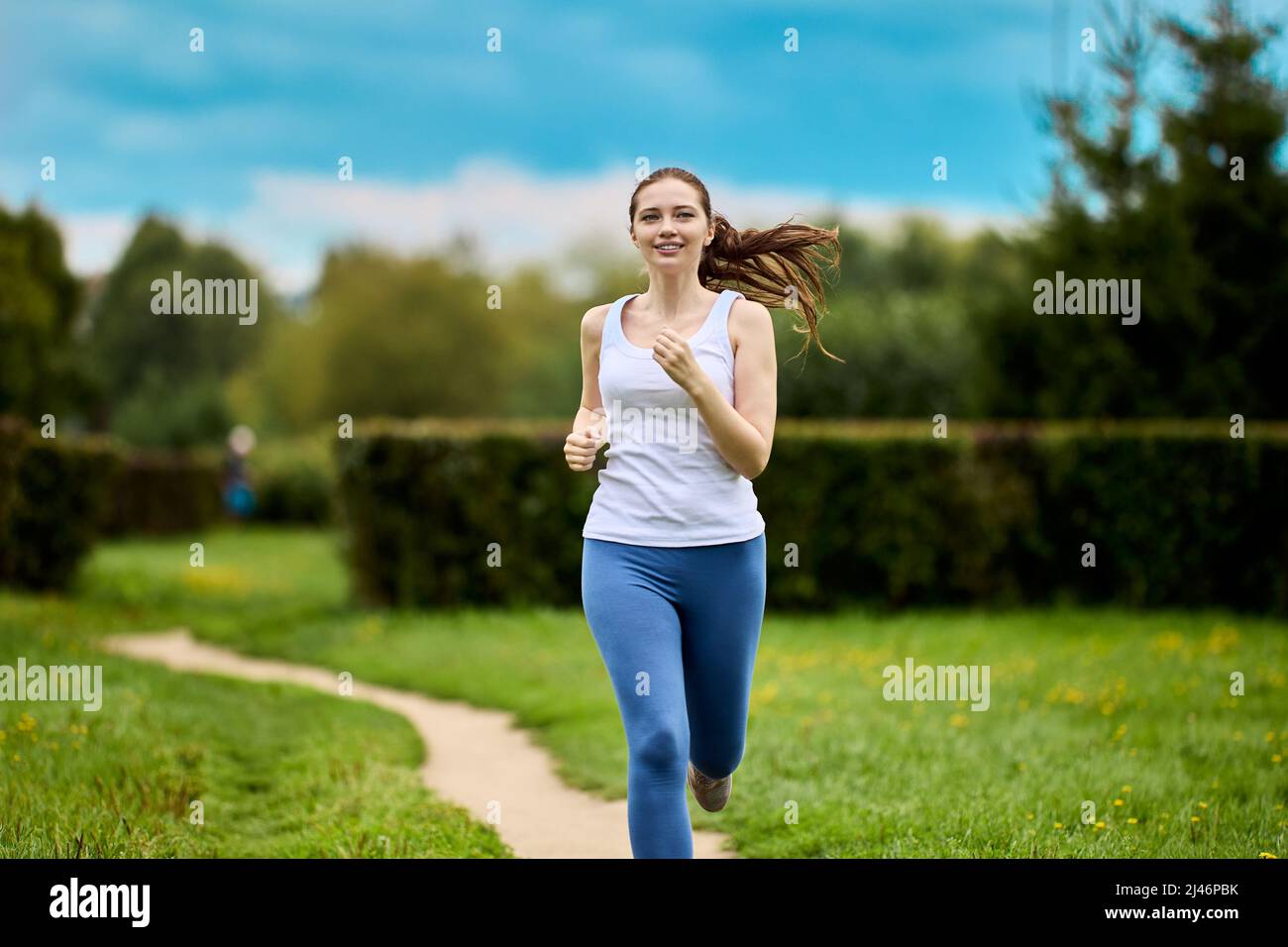 Running in city park by smiling woman at summer morning as training for ...