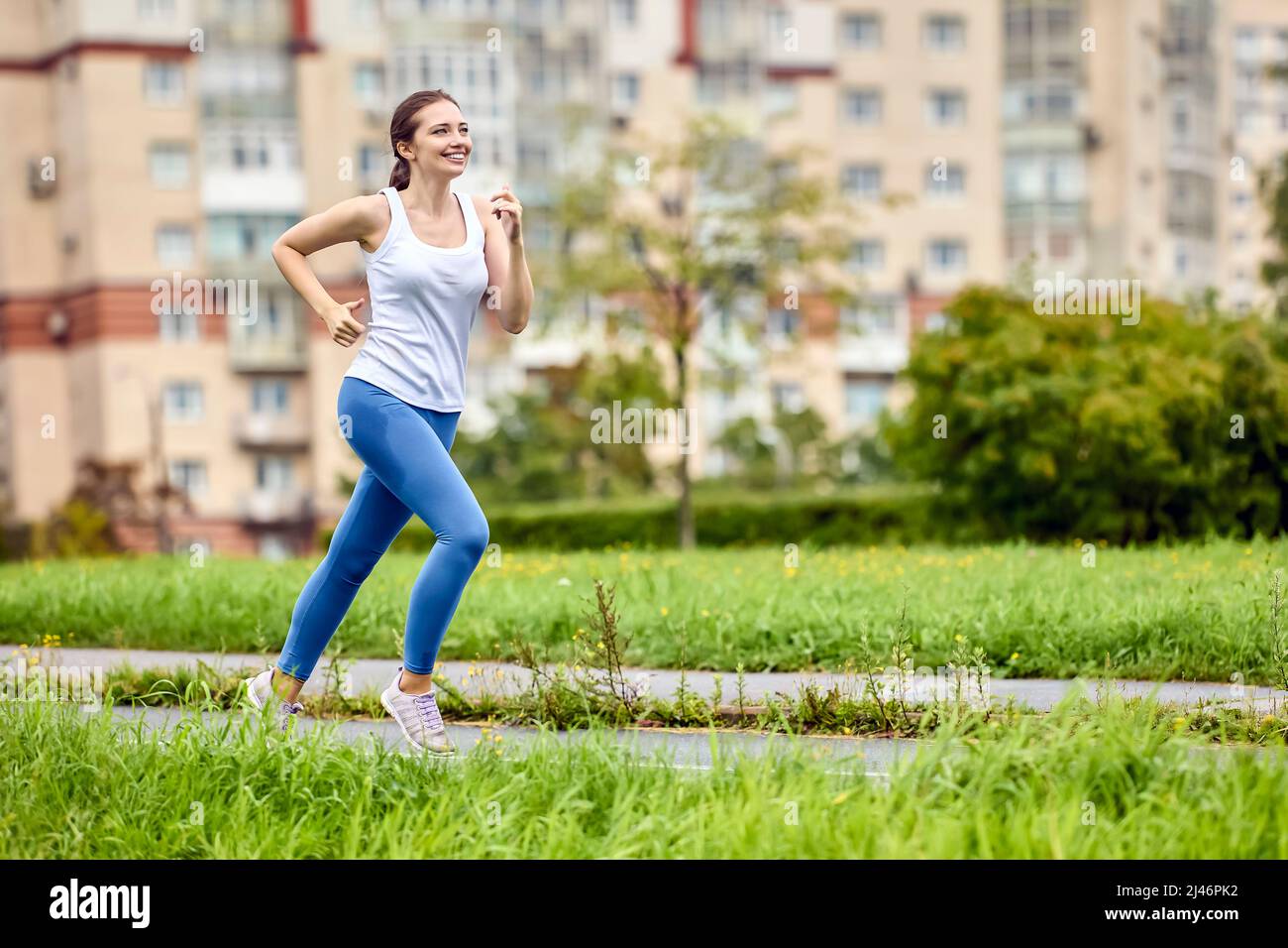 Running in summer in city park by fun woman 29 years old in leggins as ...