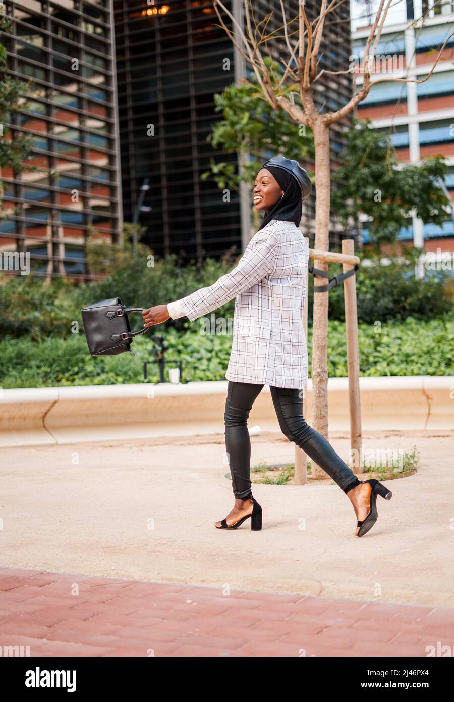 Side view full body of carefree African American female in trendy ...