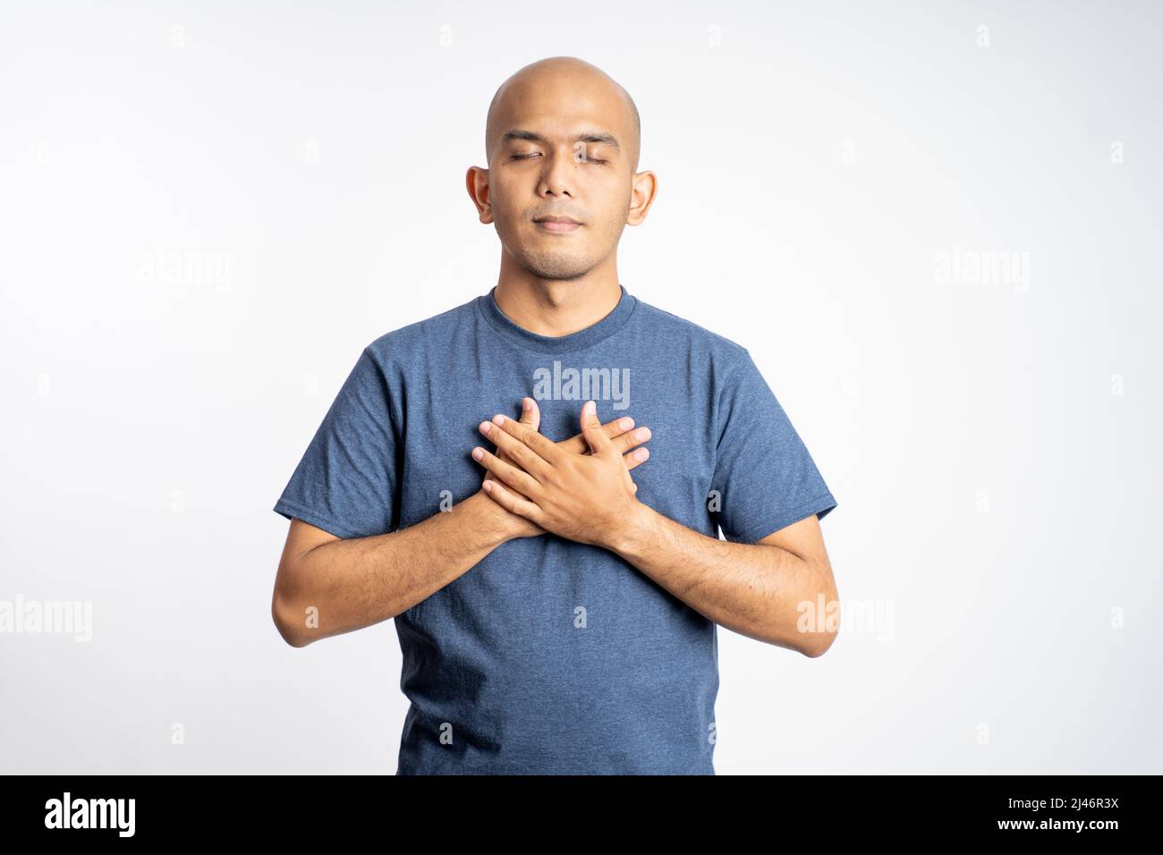 bald man holding chest and closing eyes feeling comfortable Stock Photo ...