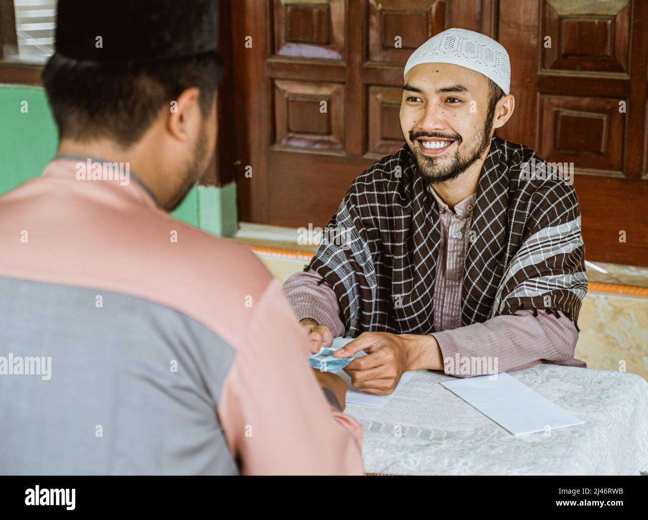 muslim man paying zakat for eid mubarak at the mosque Stock Photo - Alamy