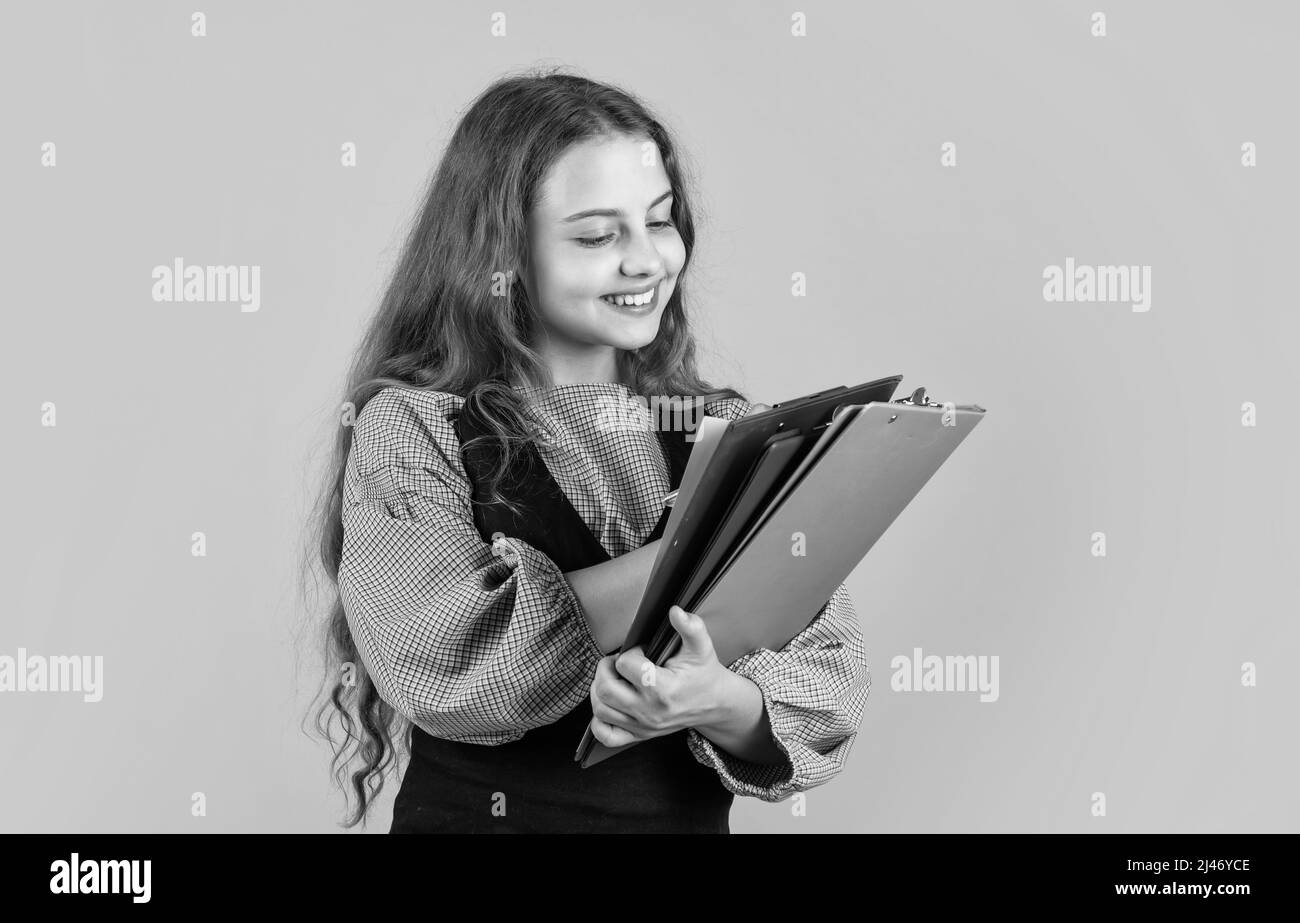 happy looking kid girl with document folder, concentrated on work Stock ...