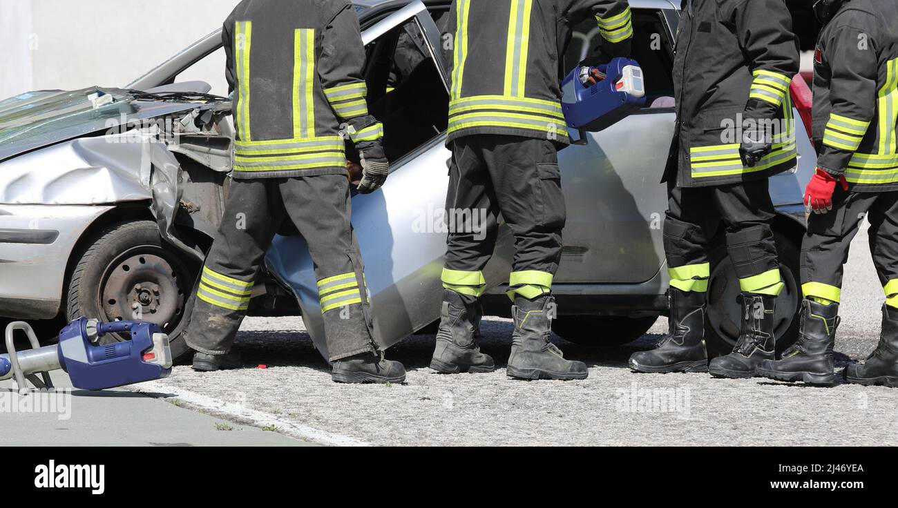 firefighter with his team while shearing the car with a powerful ...
