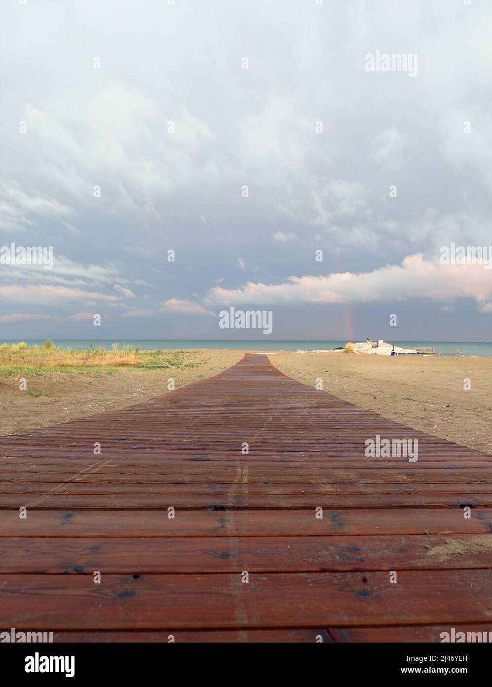 long wooden boardwalk on the beach that seems to run towards infinity ...