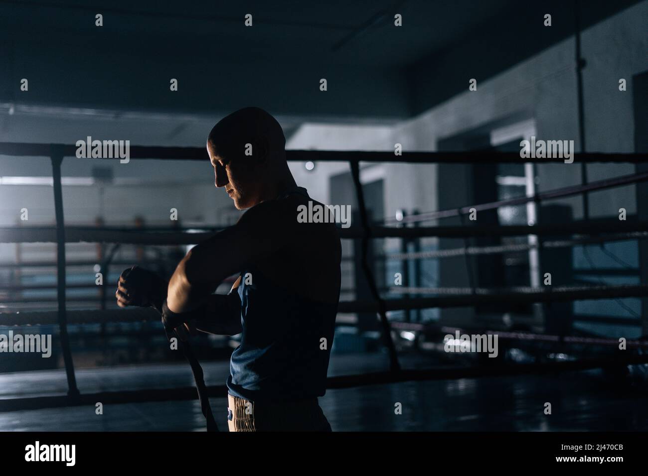 Side view of confident boxer wrapping defense boxing bandage around ...