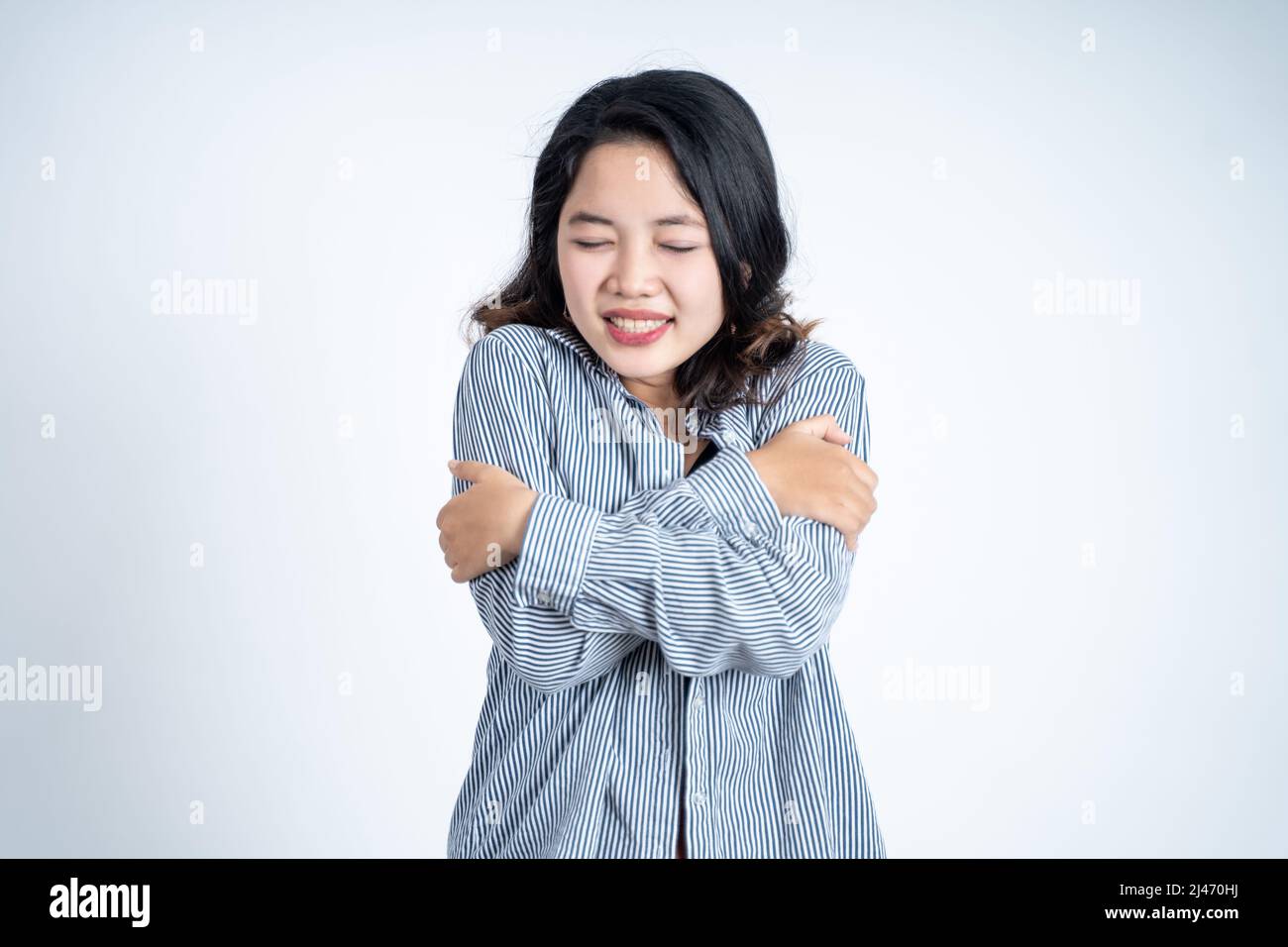 young woman feeling cold with both hands hugging her arms Stock Photo ...