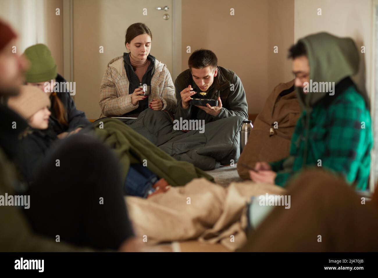 Portrait of Caucasian young couple eating simple food while hiding in ...