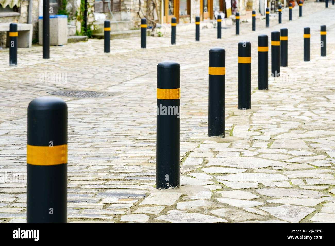 protection of a paved sidewalk from the driveway with black and yellow ...