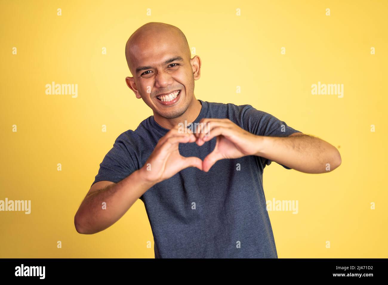 asian bald man forming a heart with finger gestures Stock Photo - Alamy