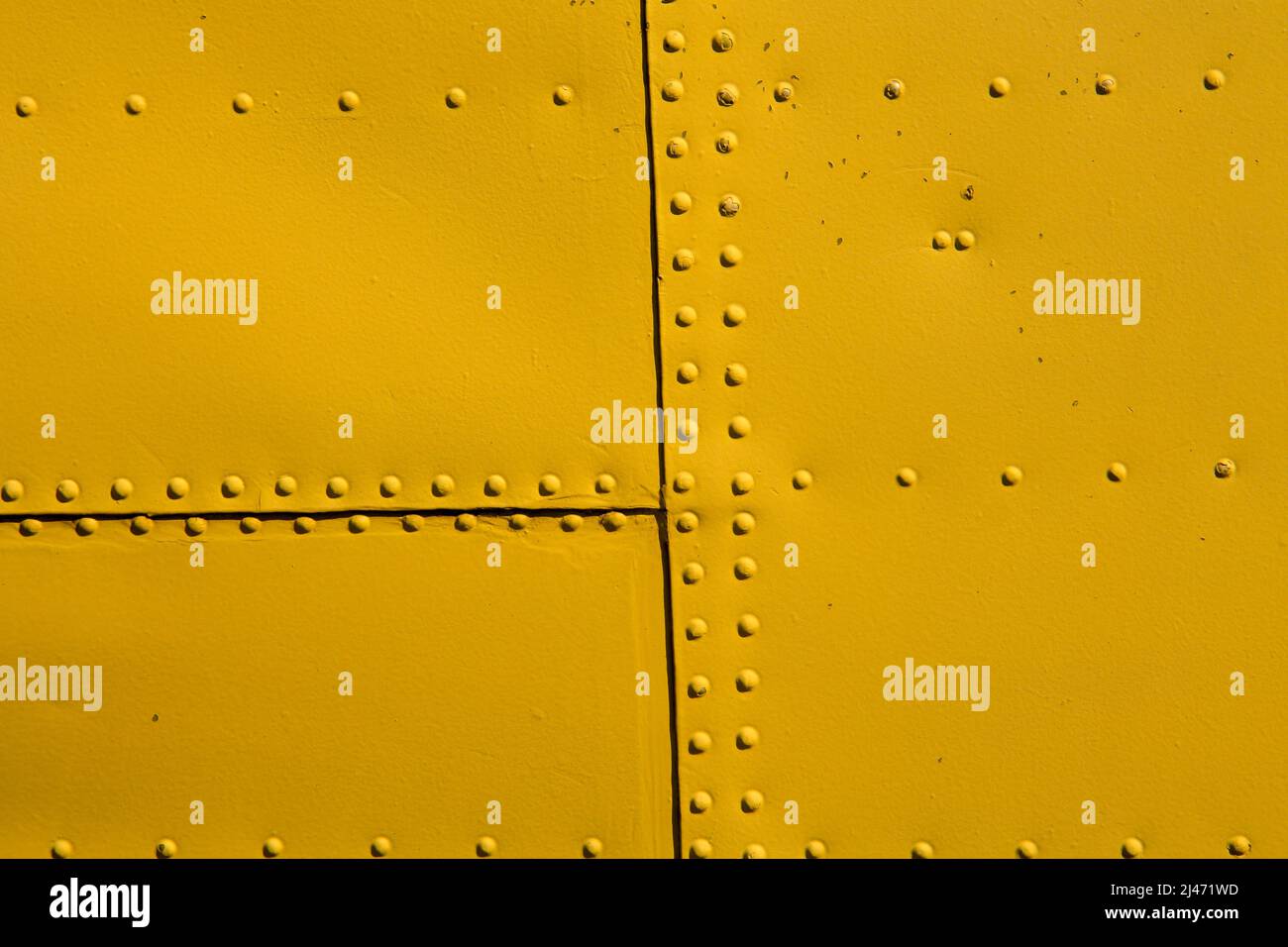 Metal texture with rows of rivets painted yellow. Bright and light ...