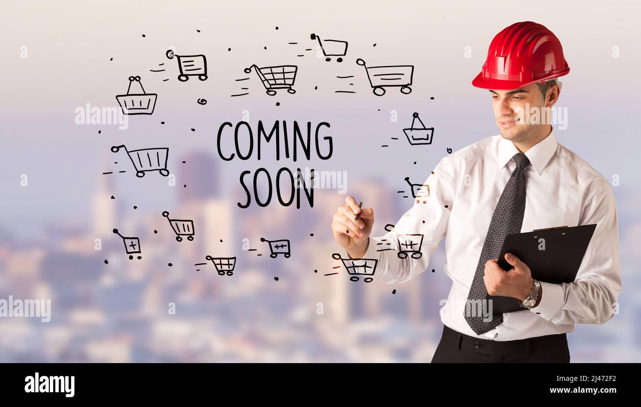 Young businessman with helmet drawing sale sign Stock Photo - Alamy