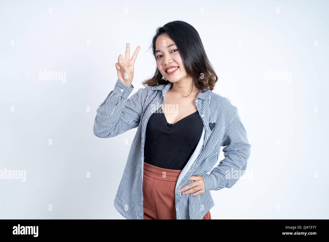 Young asian woman with peaceful hand gesture Stock Photo - Alamy