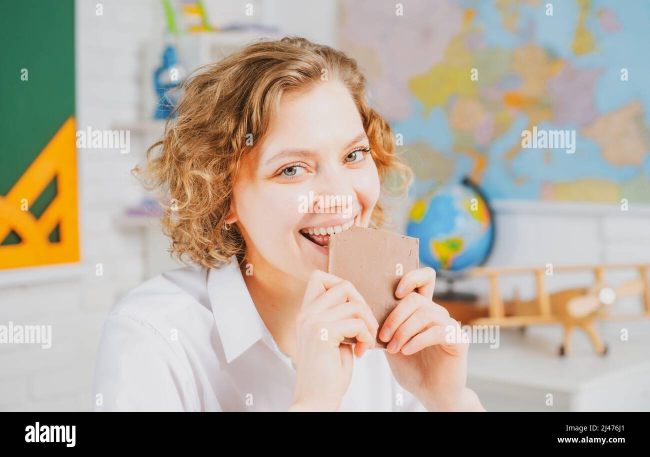 Female student closeup portrait. Young teacher or tutor eat chocolate ...