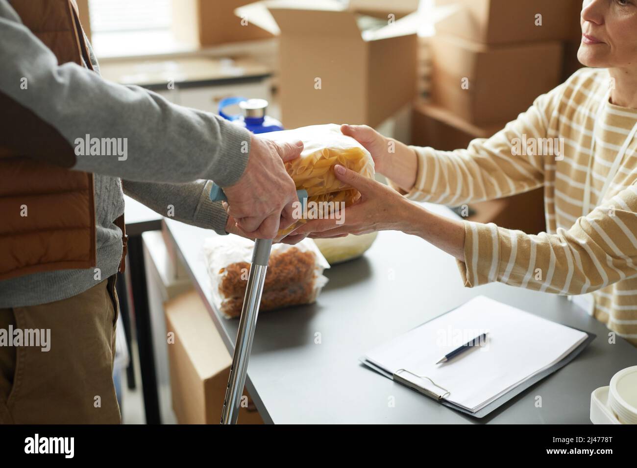 Close up of female volunteer giving out food at refugee help center ...