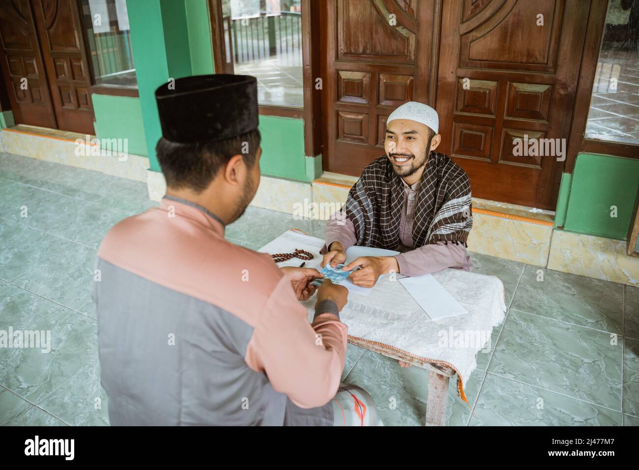 muslim man paying zakat for eid mubarak at the mosque Stock Photo - Alamy