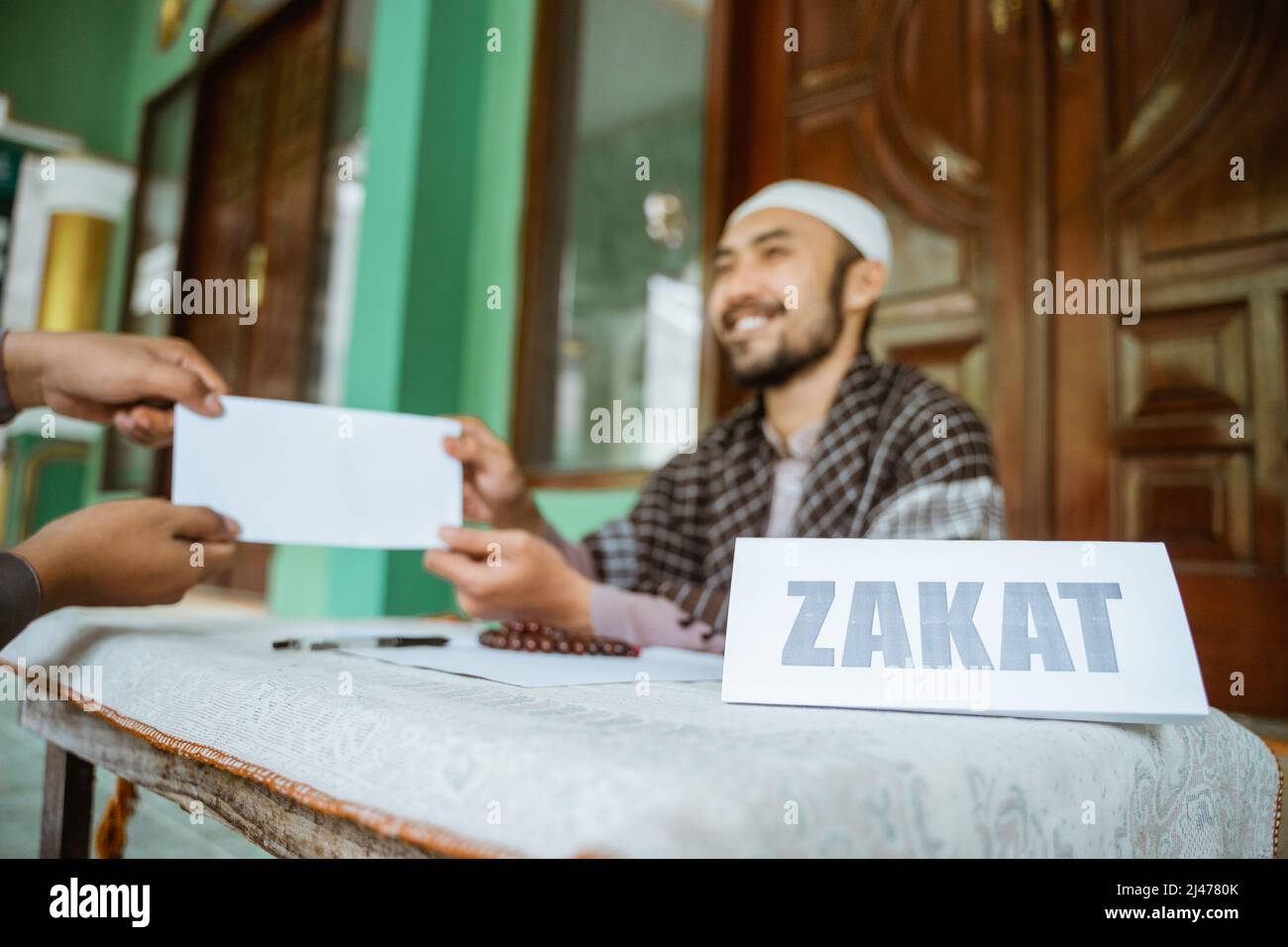 muslim man paying zakat for eid mubarak at the mosque Stock Photo - Alamy