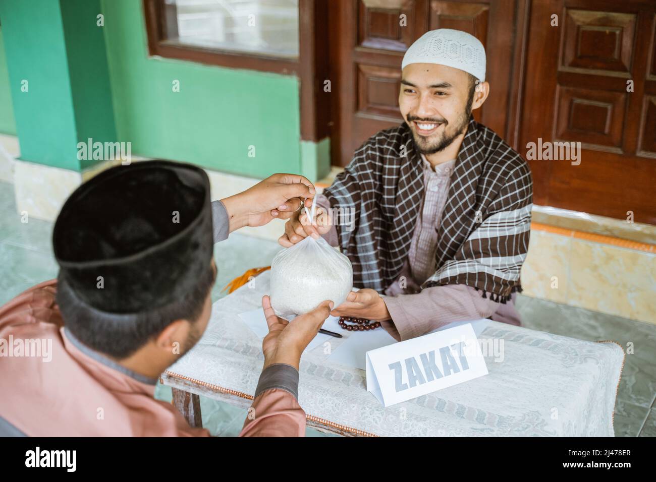 man giving a rice as a food donation for zakat during eid mubarak Stock ...