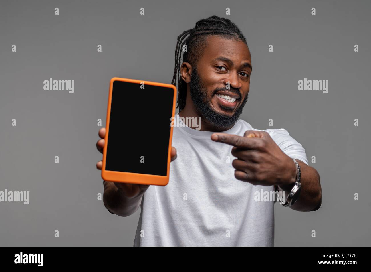 Happy African American guy demonstrating his gadget Stock Photo - Alamy