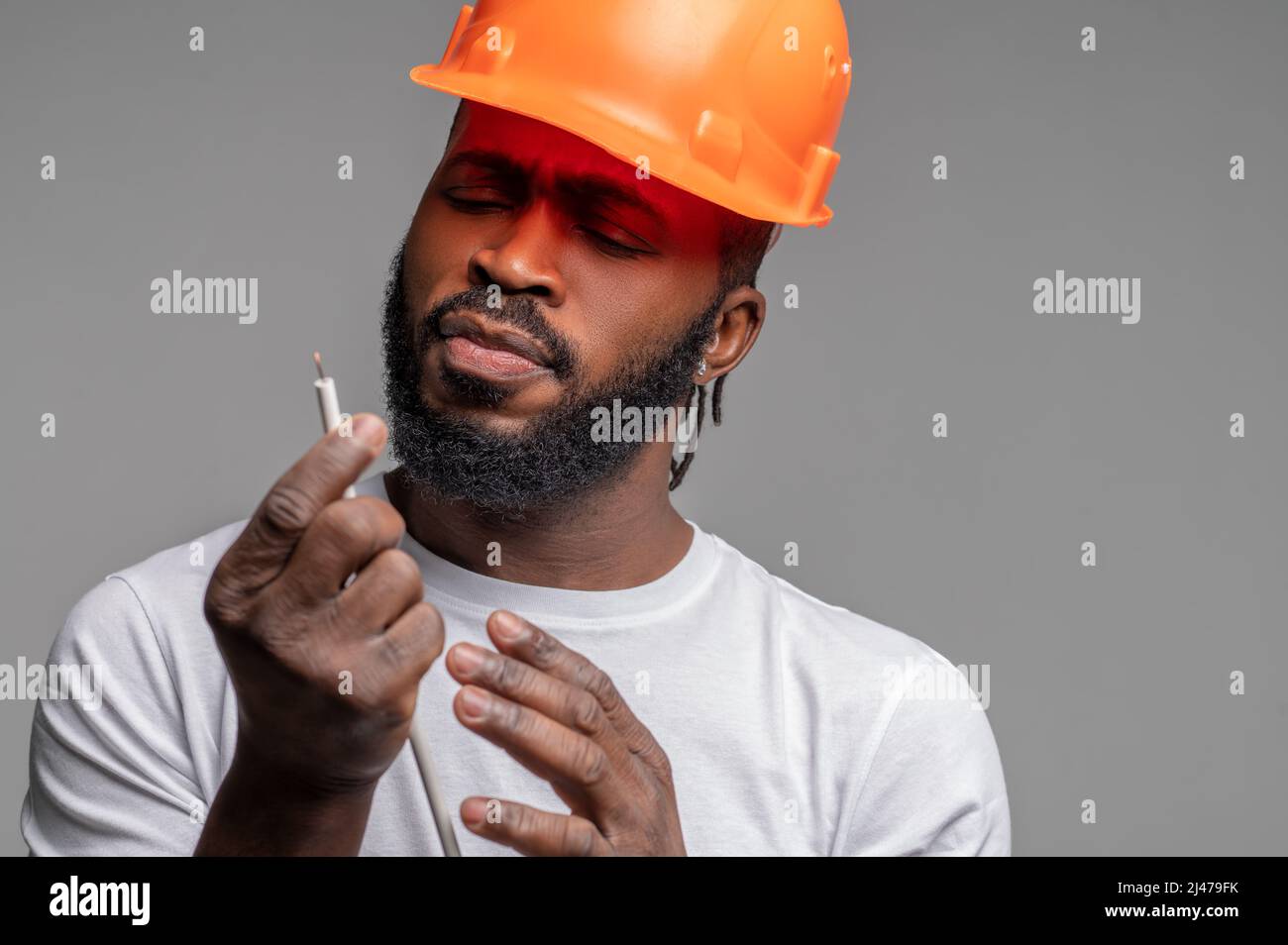 Worker examining a power cable in his hand Stock Photo - Alamy
