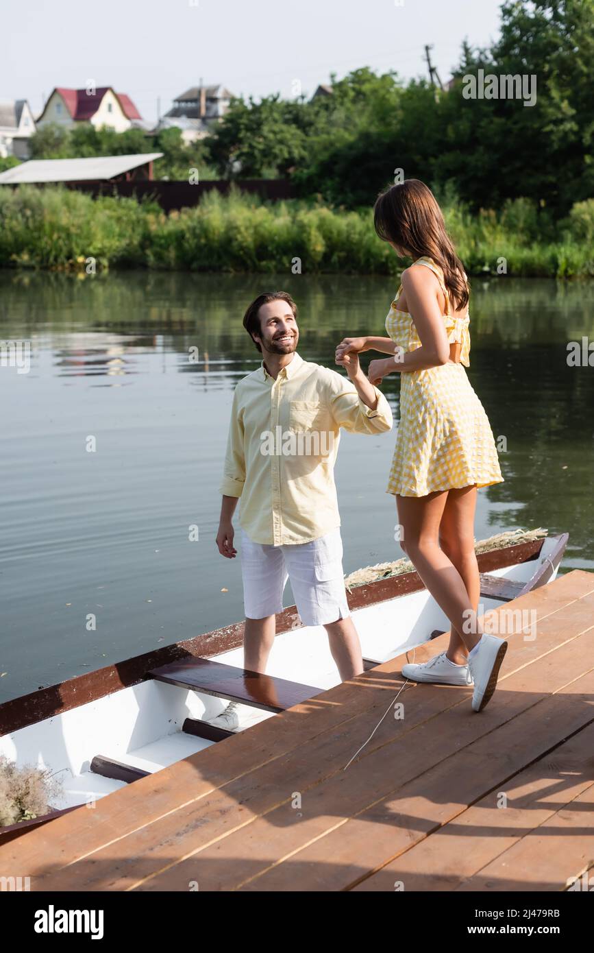 happy bearded man in summer clothes holding hands with girlfriend near ...