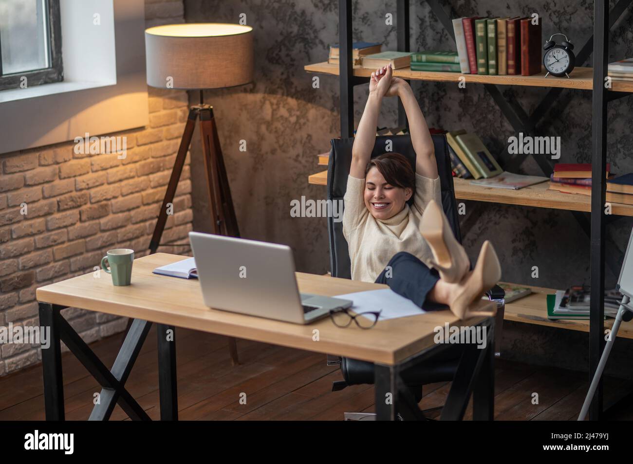 A young woman relaxing in the office after work Stock Photo - Alamy