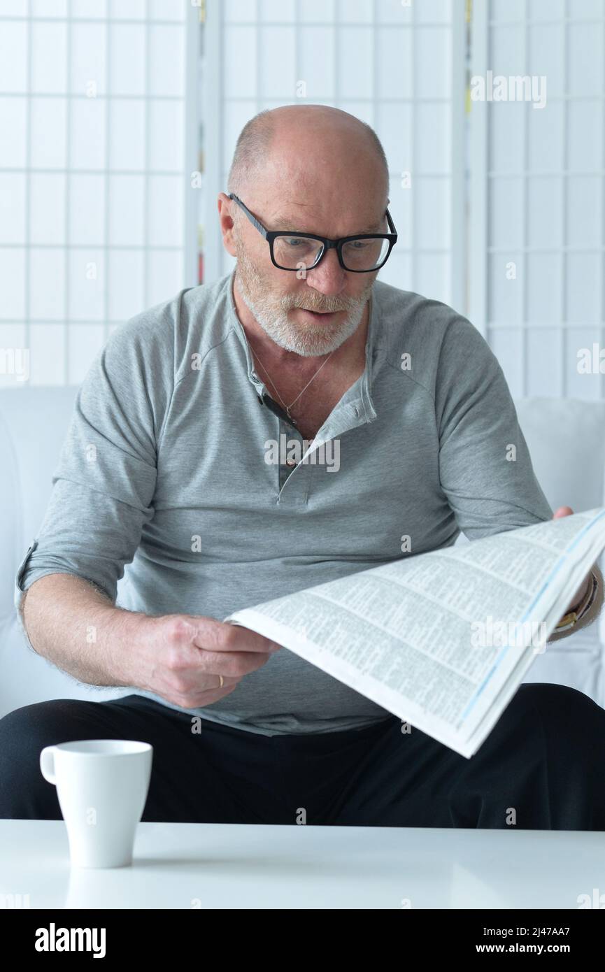 Older person reading newspaper at home hi-res stock photography and ...