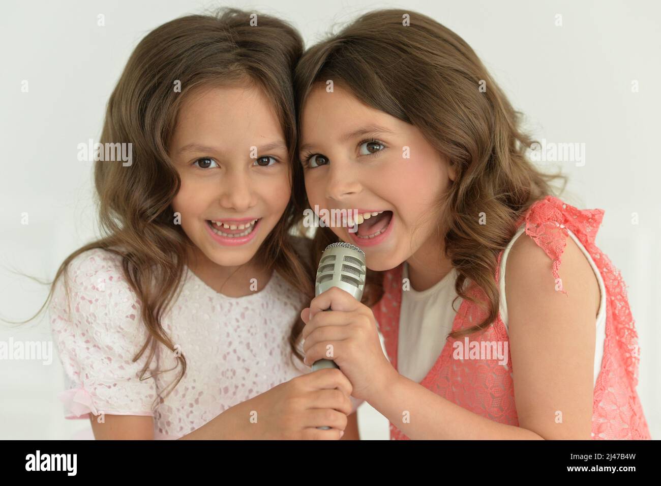 Close up view of cute little girls singing with microphone Stock Photo ...
