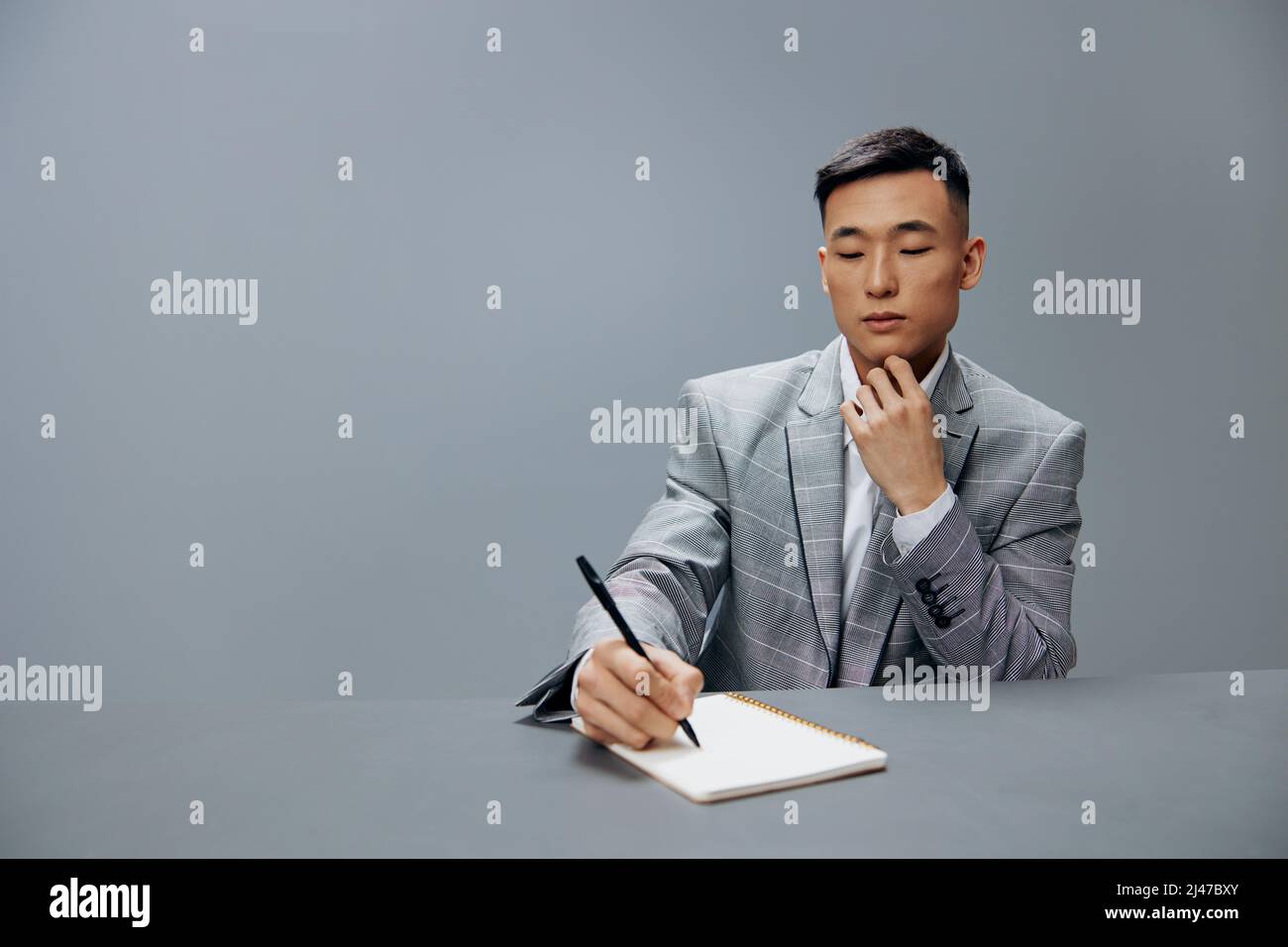 worker in a gray suit in the office with a notepad on the table the ...