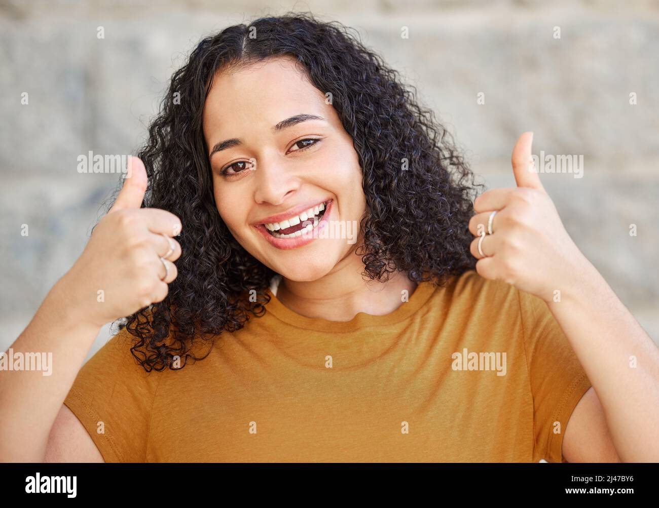 Its all good. Shot of a young woman showing thumbs up while standing ...