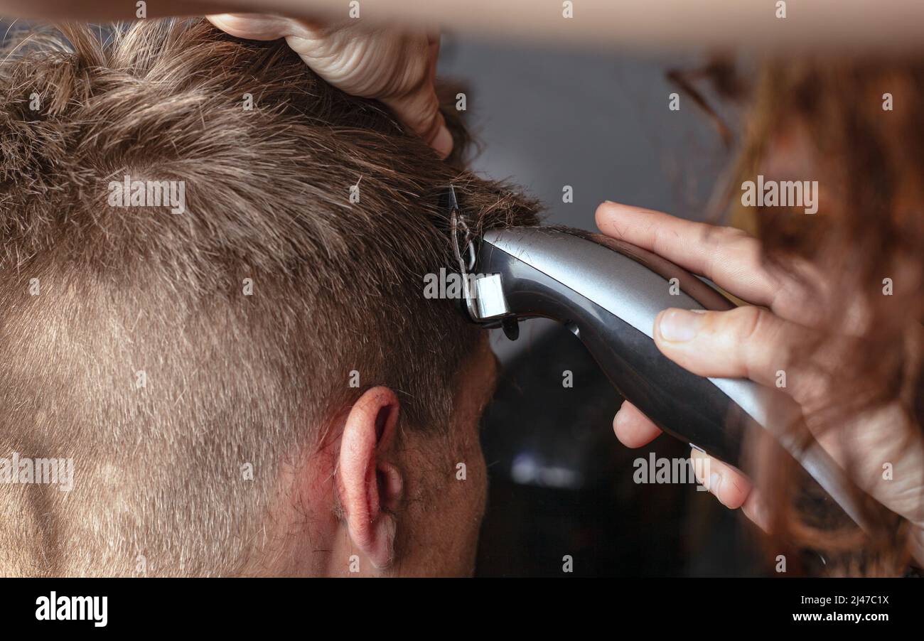 cutting hair with a trimmer, hairdresser shaves hair Stock Photo - Alamy