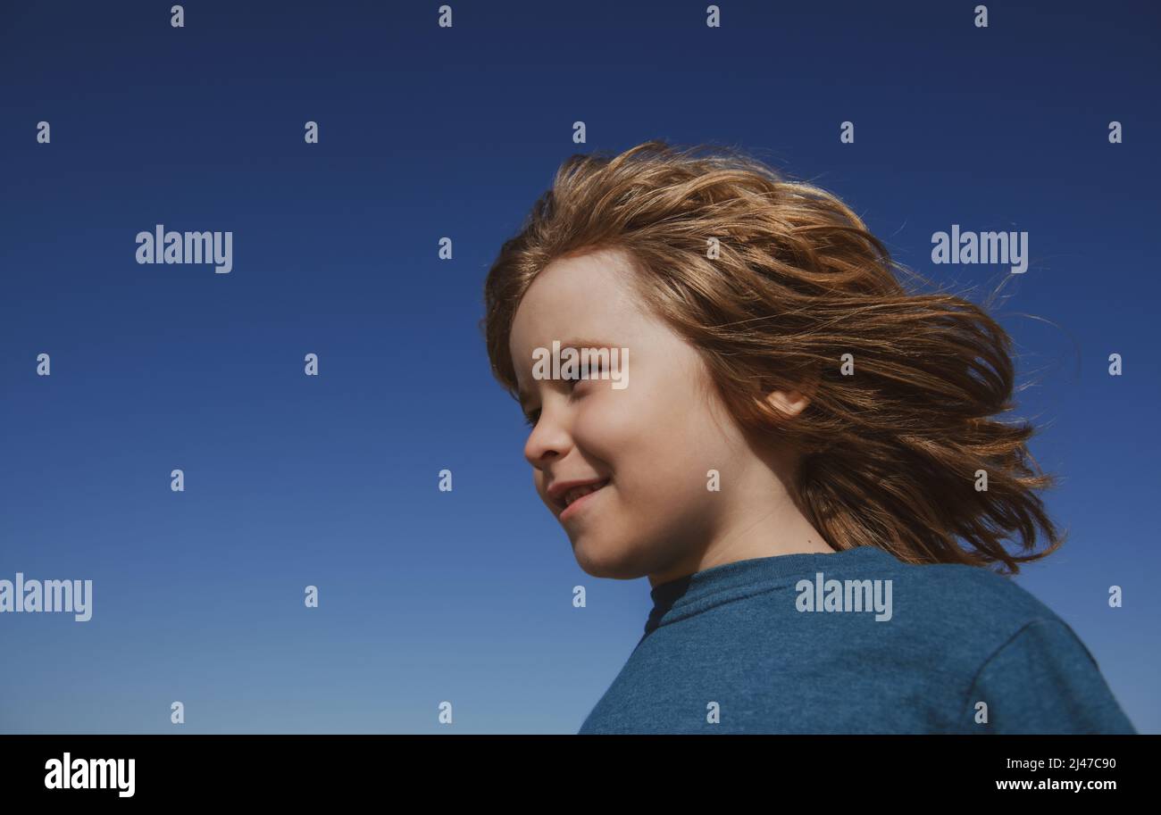 Portrait of little boy on blue sky with copy space. Concept of kids ...